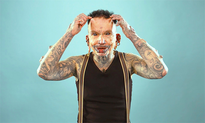 A man with 560 piercings, countless tattoos, and forehead implants ...